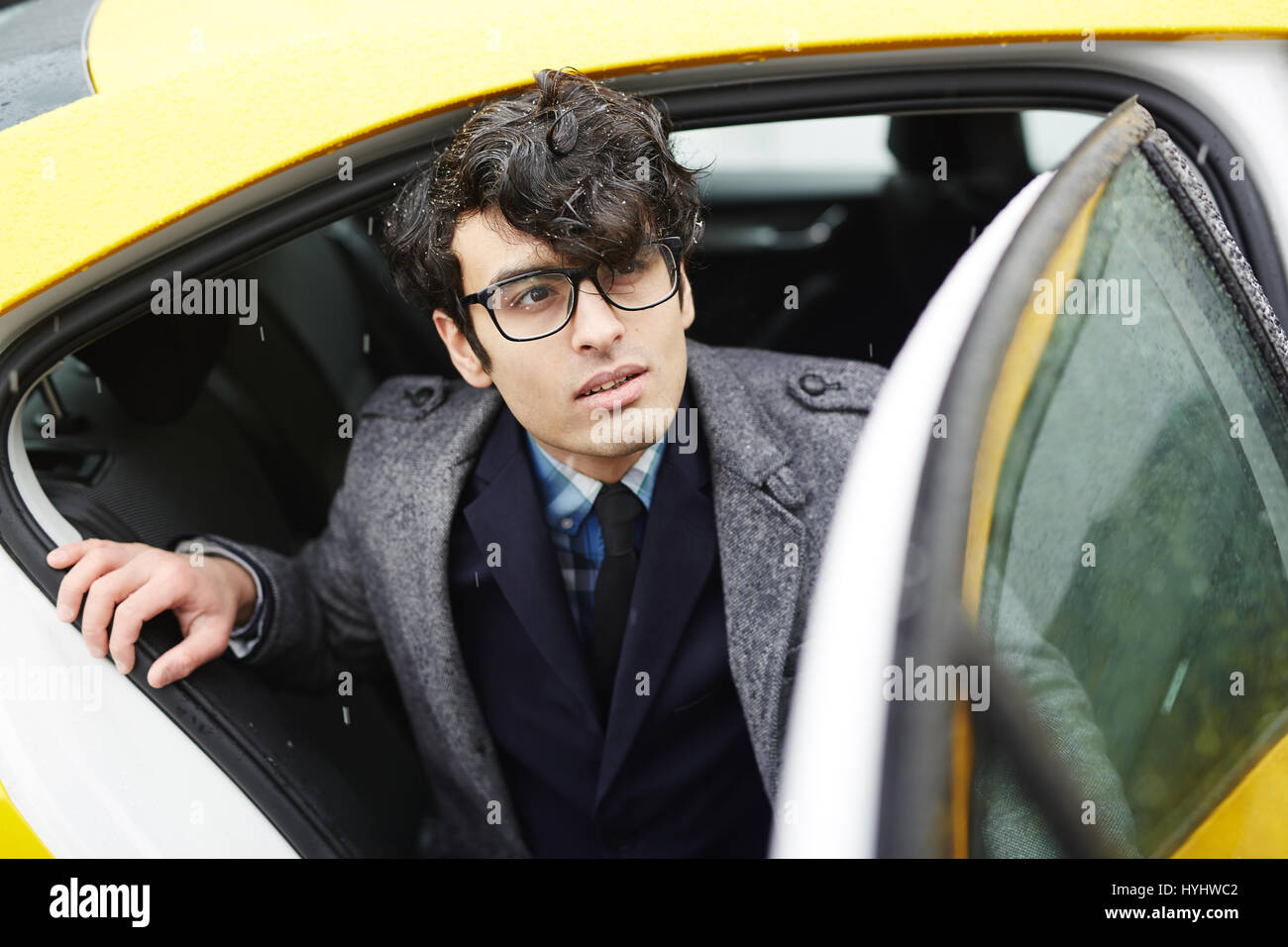 Handsome Young Businessman Leaving Taxi in Rain Stock Photo - Alamy