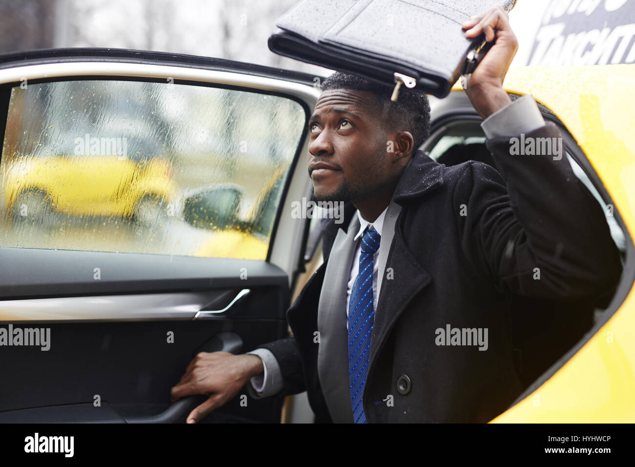 African Businessman Leaving Taxi in Rain Stock Photo - Alamy
