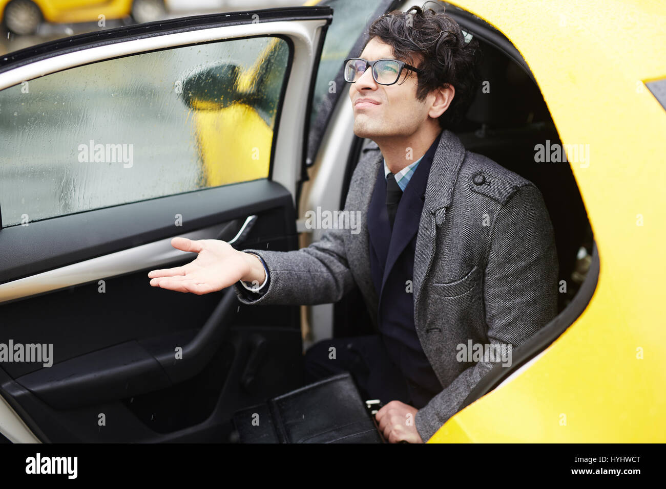 Young Businessman Leaving Taxi in Rain Stock Photo - Alamy