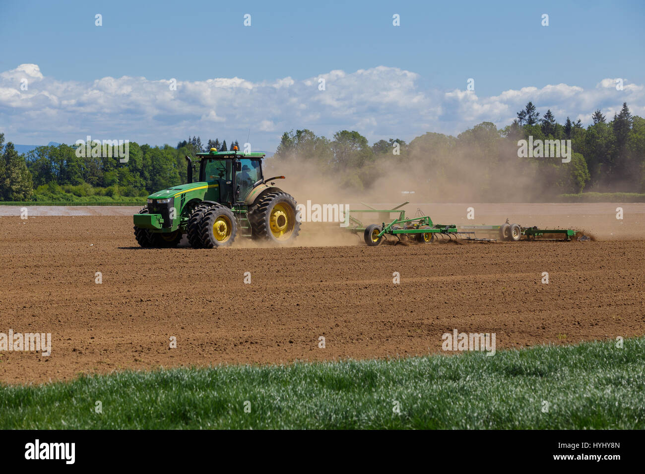ALBANY, OR - MAY 7, 2015: John Deere commercial tractor plowing a field ...