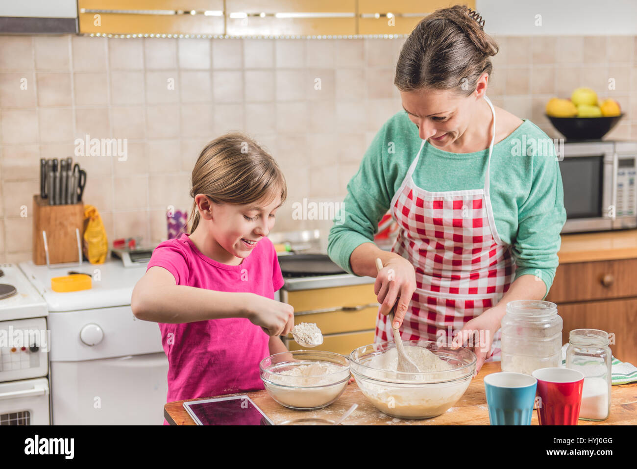 Daughter and mother making pizza dough in the kitchen Stock Photo - Alamy