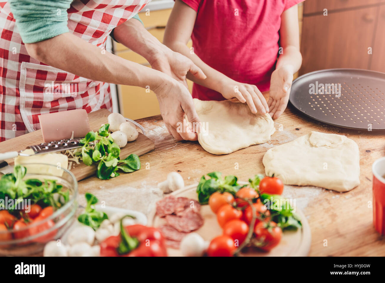 Mother and daughter preparing pizza in the kitchen Stock Photo - Alamy