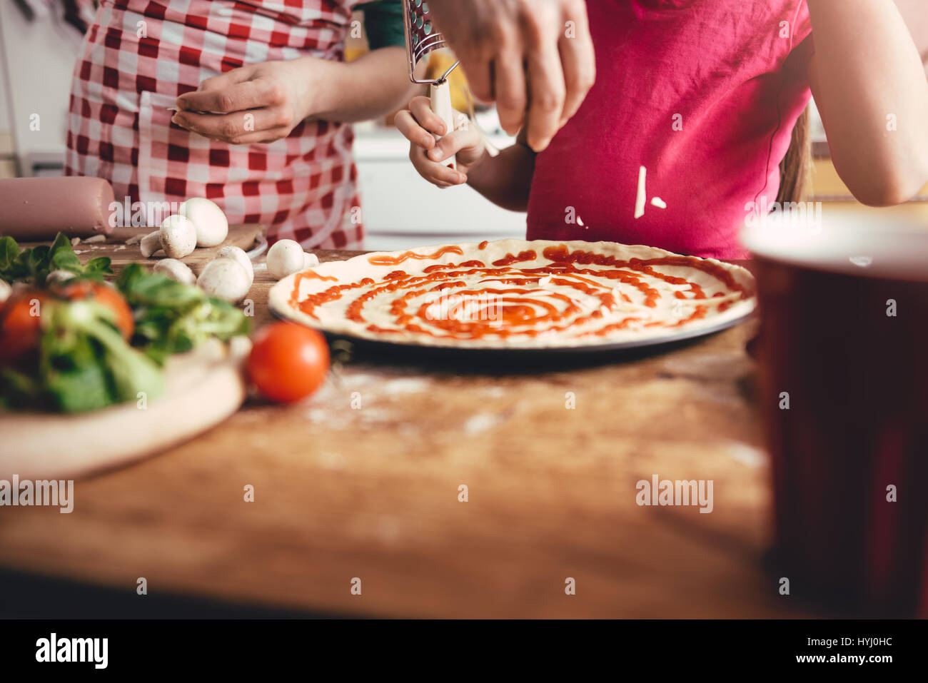 Mother and daughter preparing pizza in the kitchen Stock Photo - Alamy