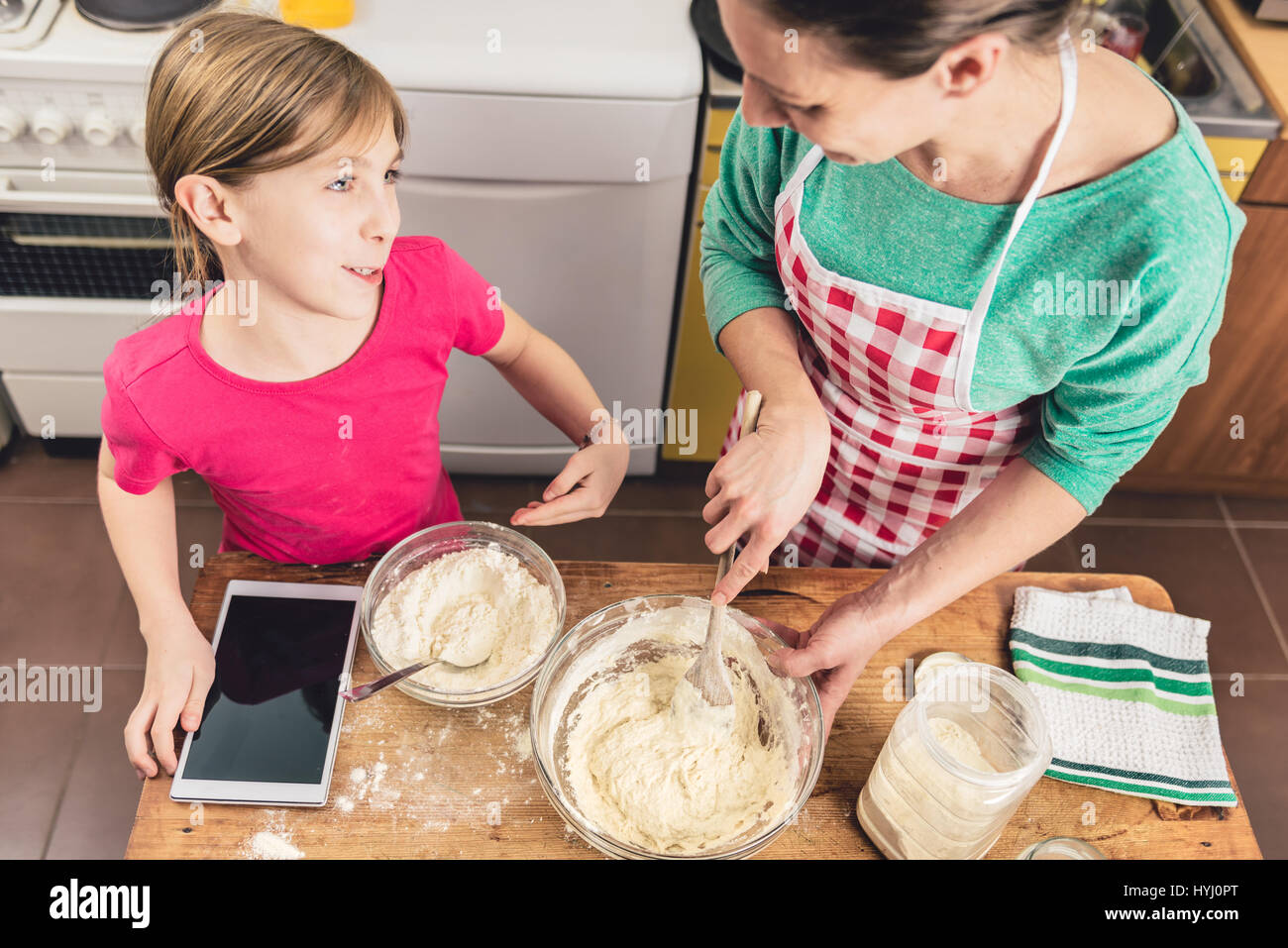 Daughter and mother making pizza dough in the kitchen Stock Photo - Alamy
