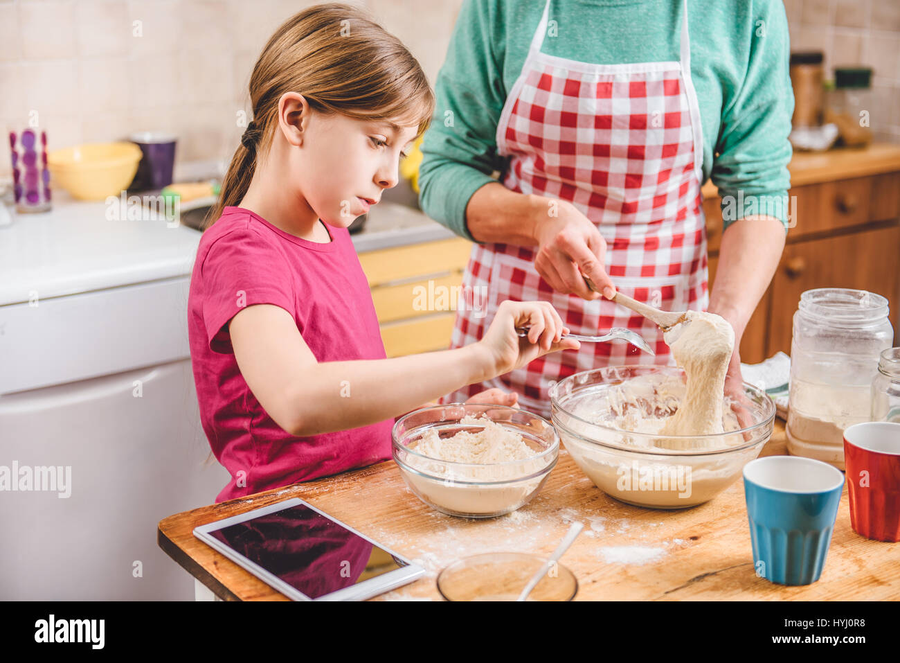 Daughter and mother making pizza dough in the kitchen Stock Photo - Alamy