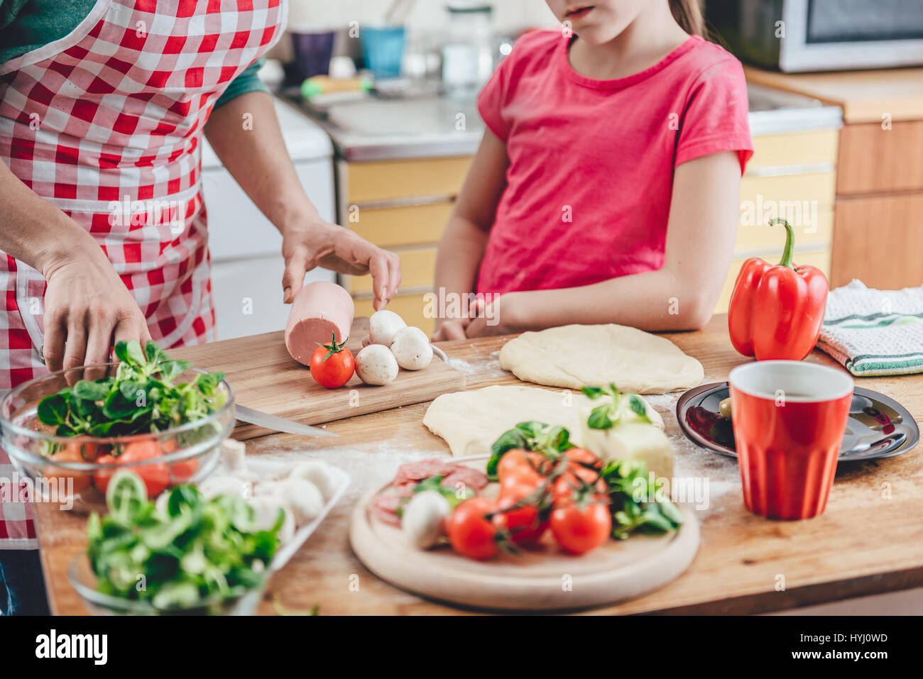 Mother and daughter preparing pizza in the kitchen Stock Photo - Alamy