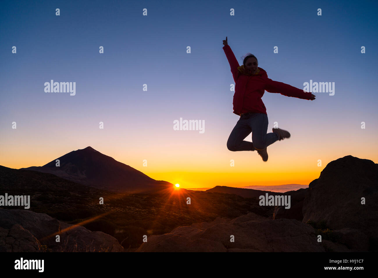 Young woman jumping in the air, on rocks, joy, Sunset, Volcano Teide ...
