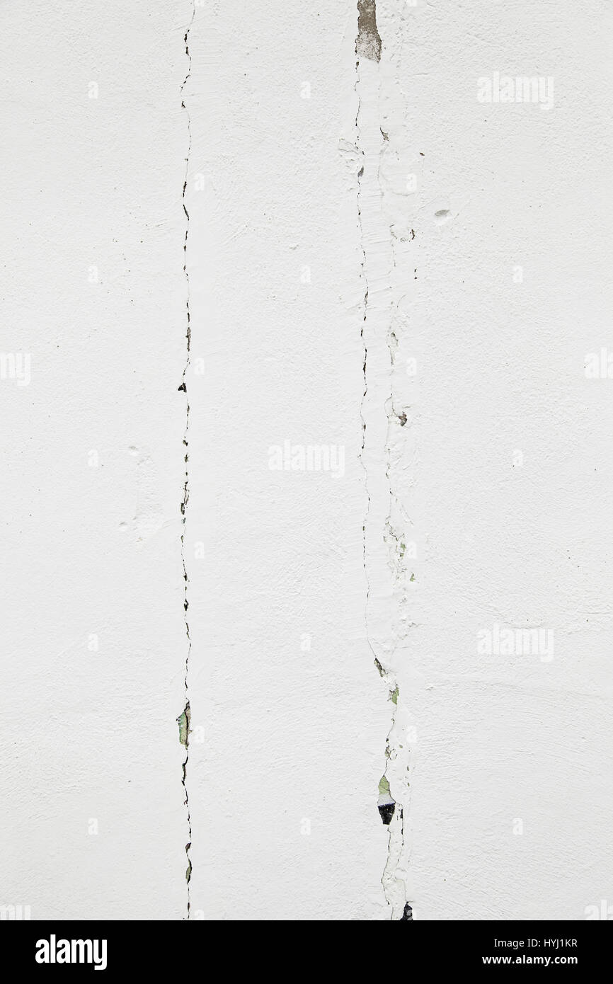 White wall with cracks, detail of a deteriorated wall, textured ...