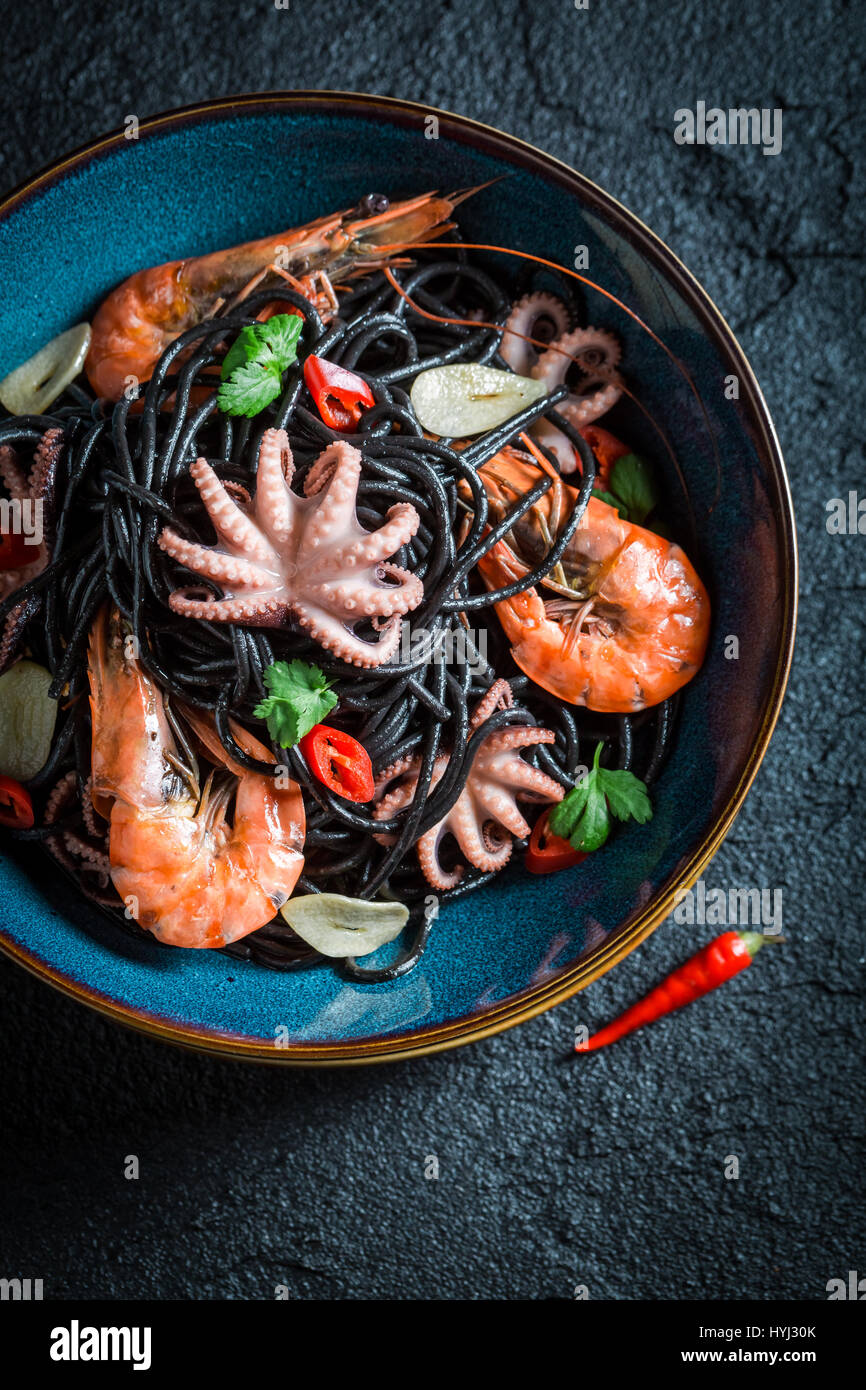 Delicious seafood black pasta made of octopus, tiger prawns Stock Photo ...