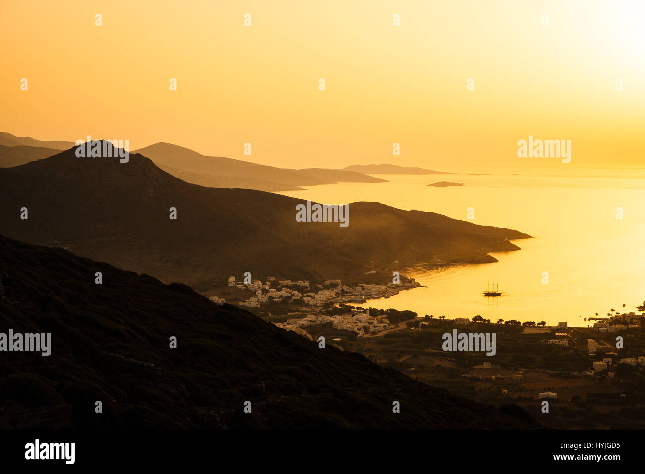 Landscape view of dramatic ocean coastline and port at sunset, Amorgos island, Cyclades, Greece ...