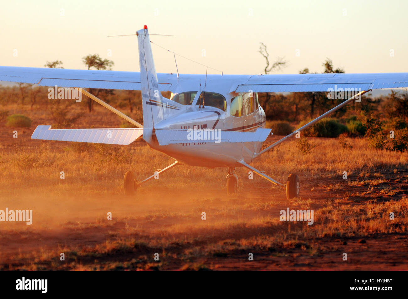 A rear view of a Cessna 172 taking off from an outback airstrip in the ...
