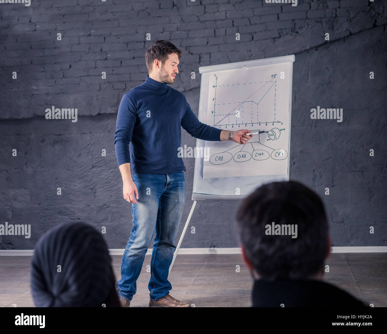 Young speaker man talking to audience during conference. He is giving a ...