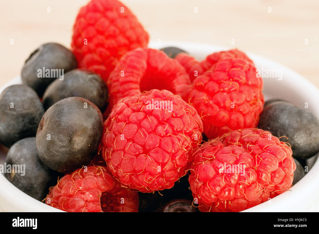 Berry mix of raspberry and blueberry in a white cup Stock Photo - Alamy