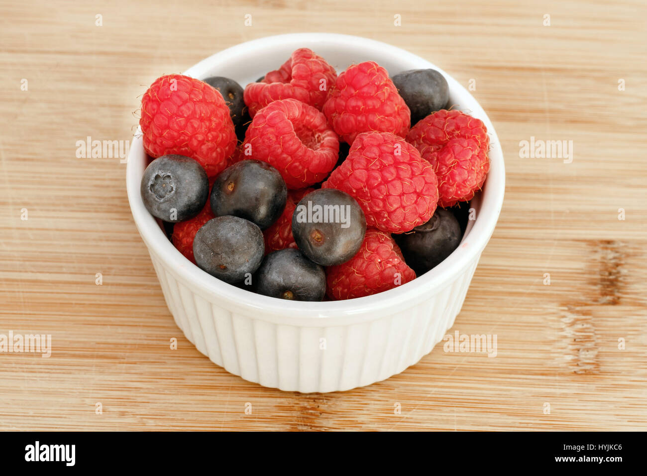 Berry mix of raspberry and blueberry in a white cup Stock Photo - Alamy