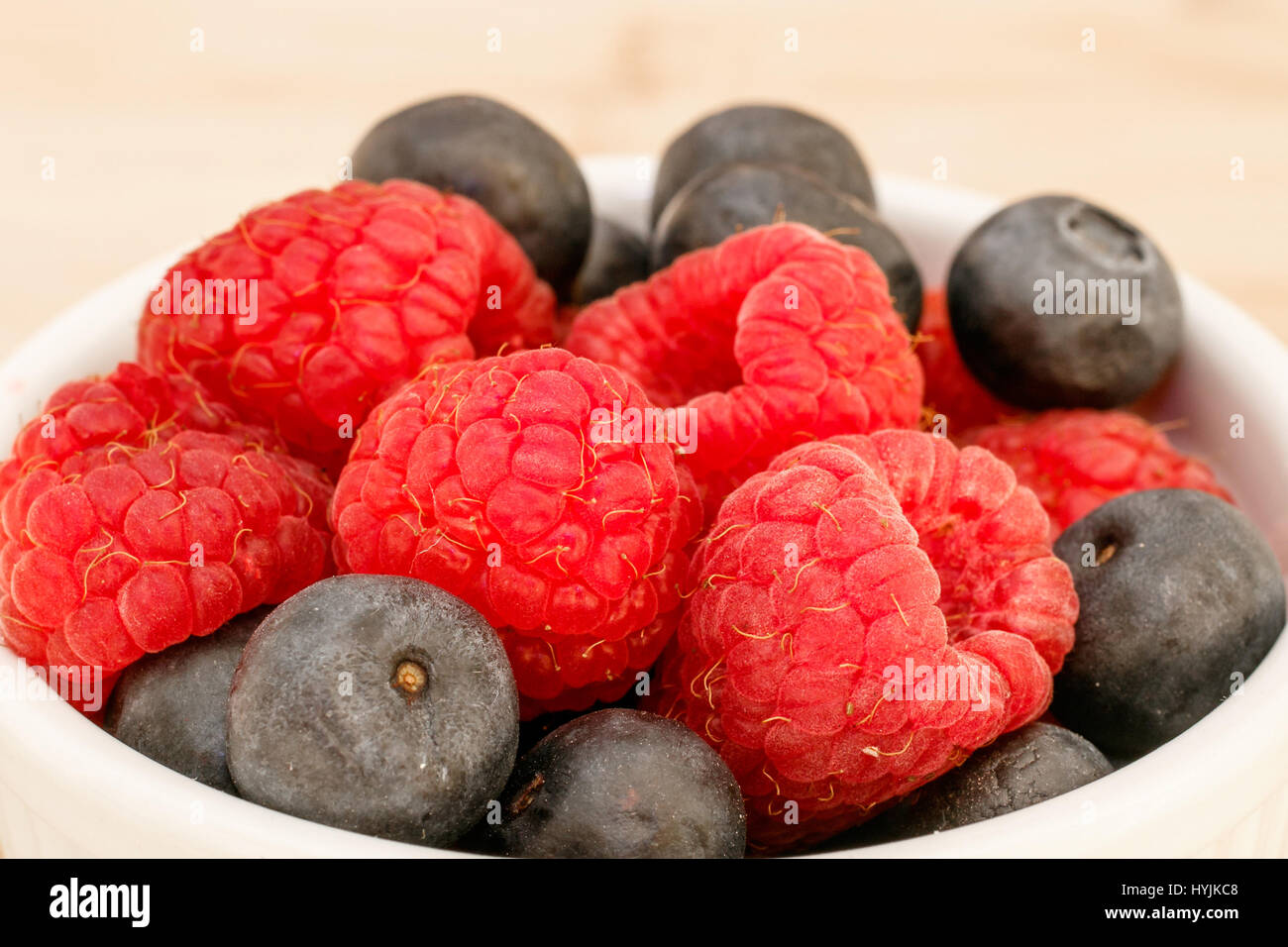 Berry mix of raspberry and blueberry in a white cup Stock Photo - Alamy