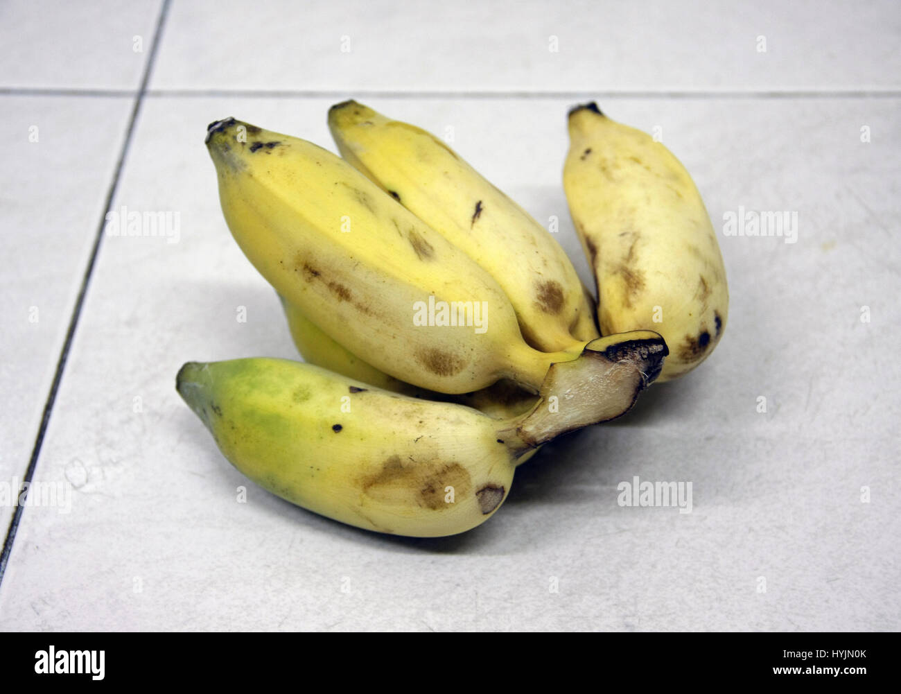 half a banana comb on white tiled floor Stock Photo - Alamy