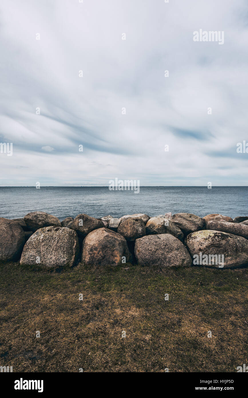 Large rocks on sea shore water's edge, seascape on cold winter day ...