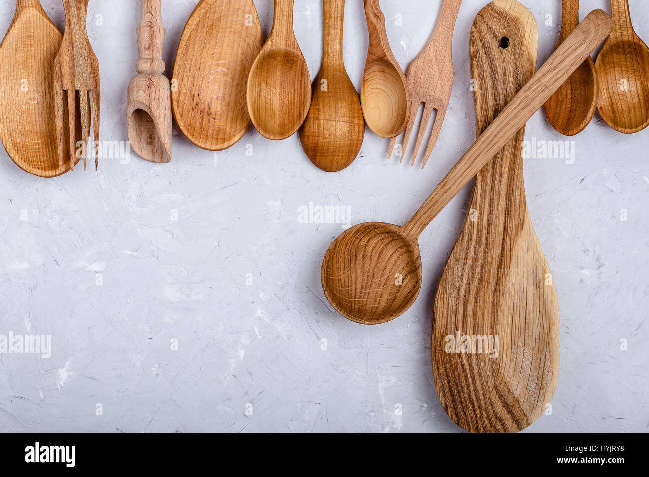 Frame of kitchen wooden utensils. Spoons and forks on light gray color ...