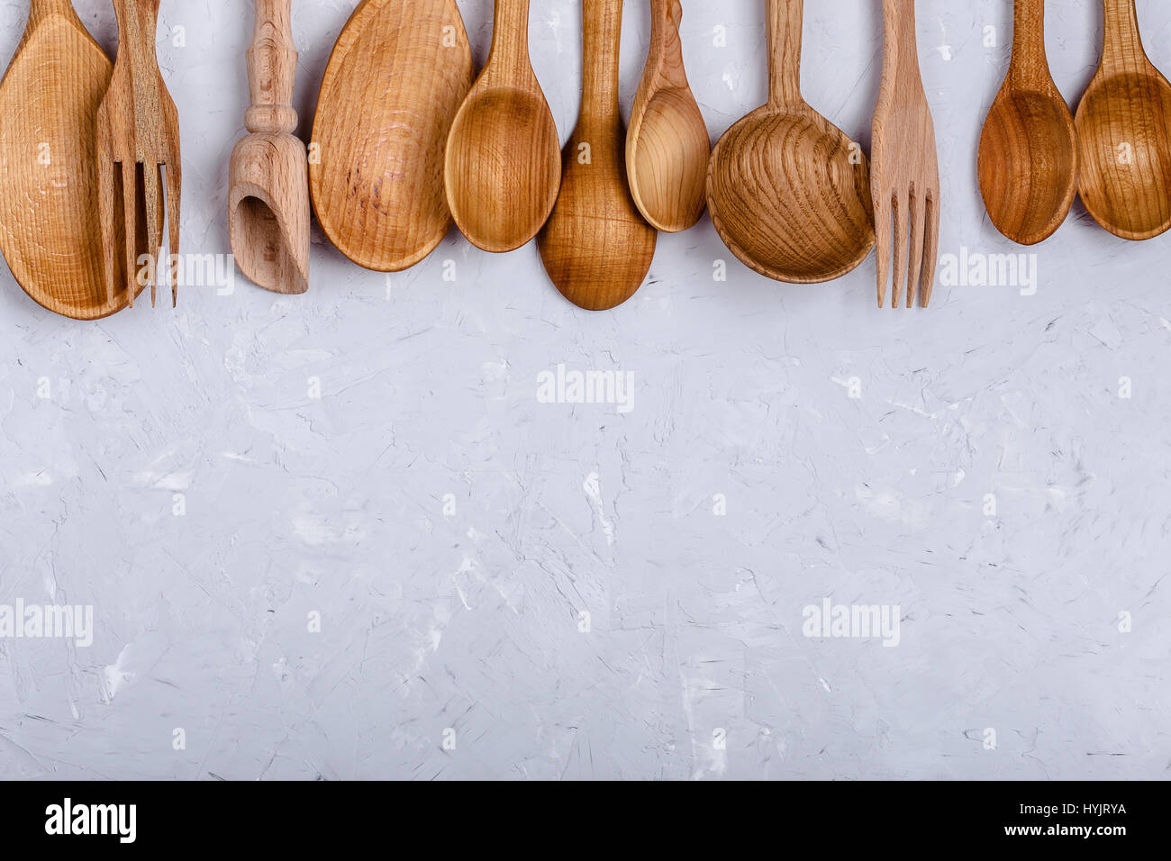 Frame of kitchen wooden utensils. Spoons and forks on light gray color ...