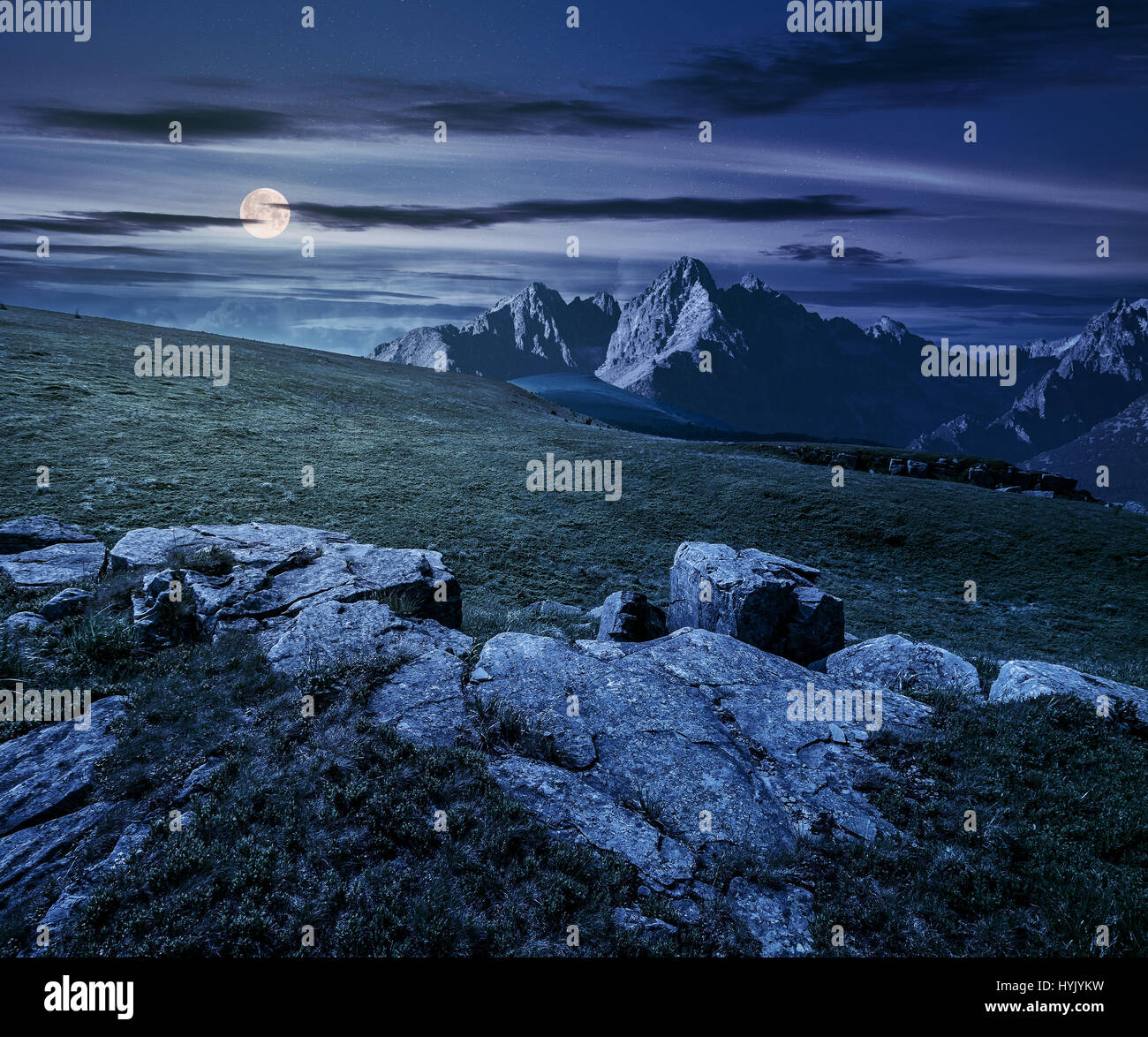 Composite night landscape with full moon. rocky peaks of mountain ridge ...