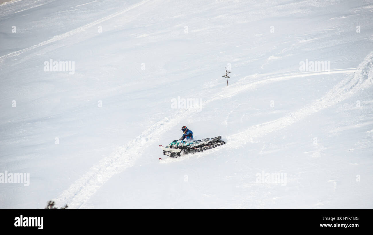 Rider on the snowmobile in the mountains . the movement of the traverse ...