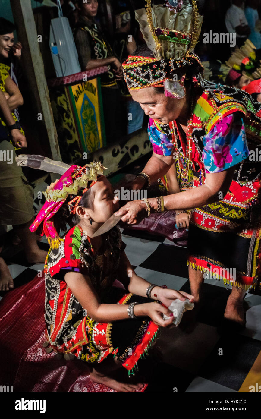 A senior woman conducting a ritual with a child, a part of a welcome ...