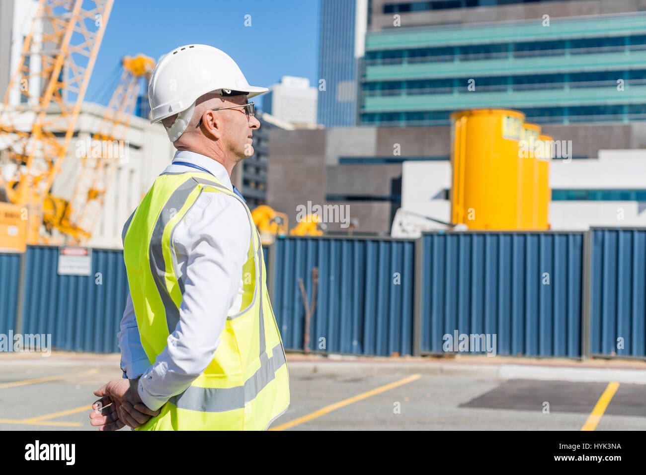 Senior foreman in glasses doing his job at building area on sunny day ...