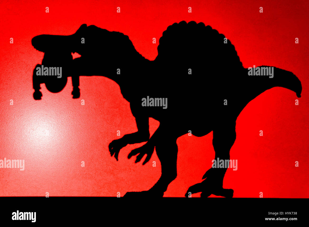 red spot light projection shadow of a spinosaurus with a dead body in ...