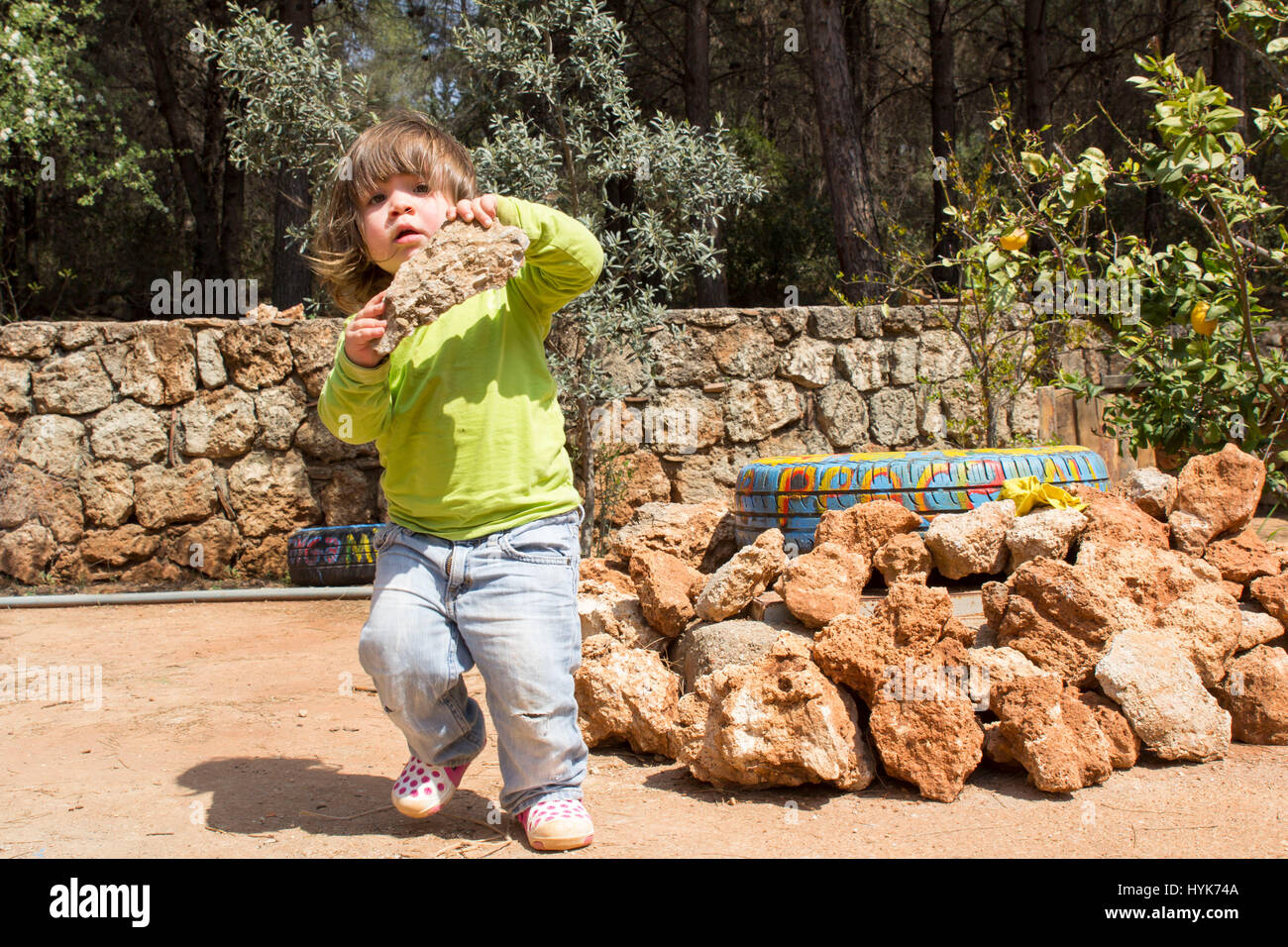 child carying big rock in garden Stock Photo - Alamy