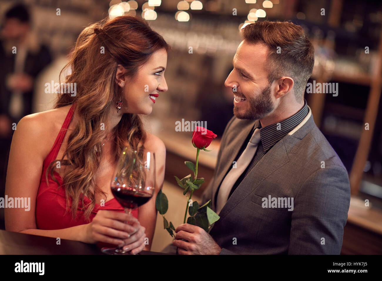 Handsome man giving rose to attractive lady Stock Photo - Alamy