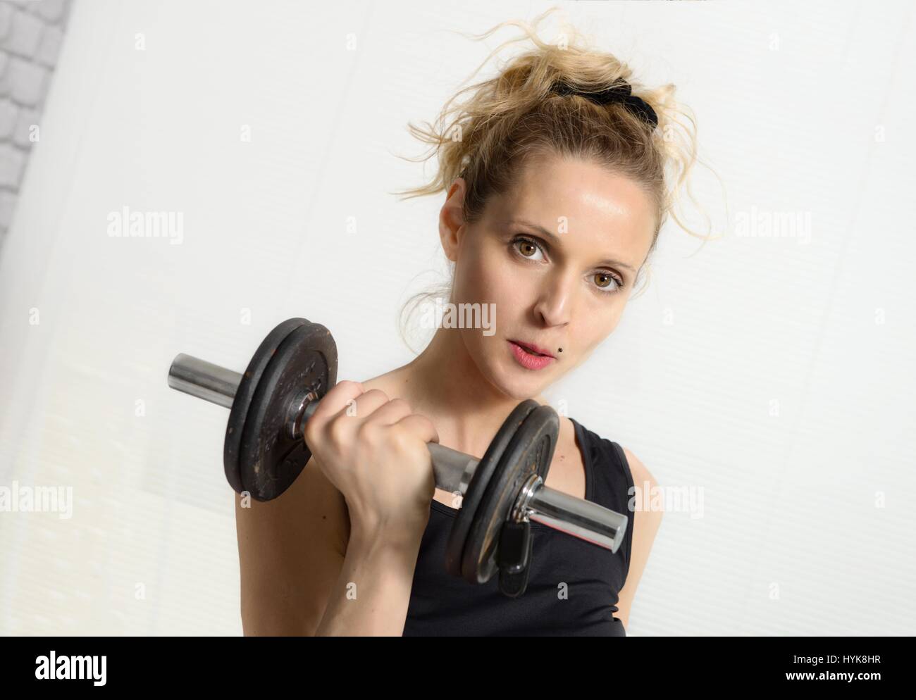 pretty blonde fitness woman lifting dumbbells Stock Photo - Alamy