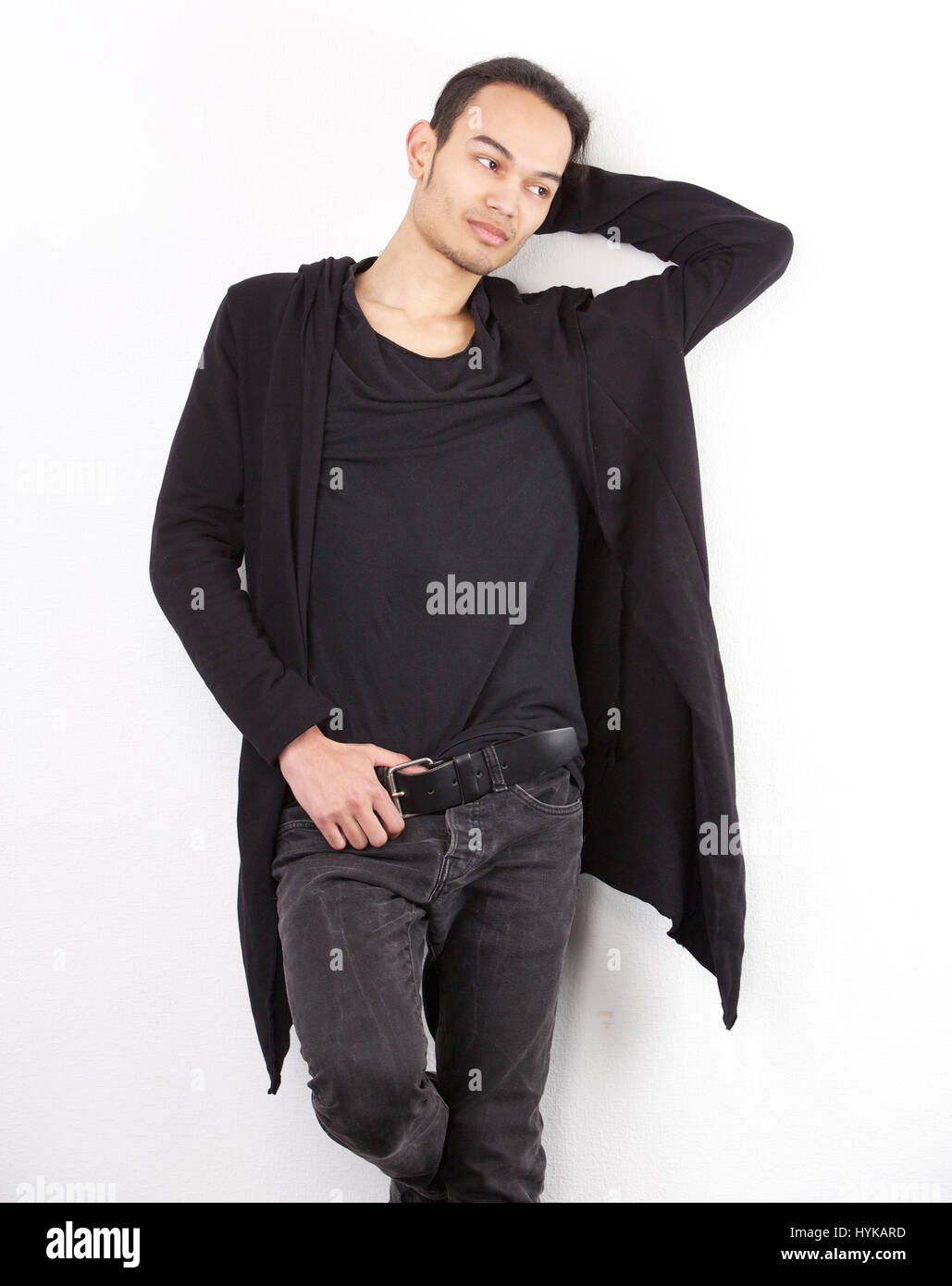 Portrait of a handsome young asian male fashion model relaxing against ...