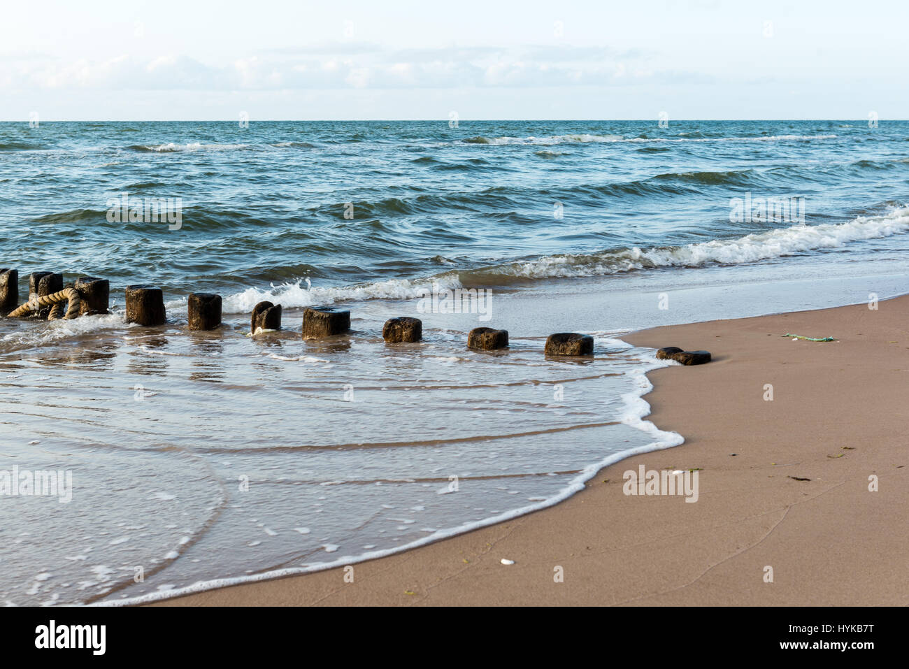 Breakwater of one row of wooden poles at the Sea coast Stock Photo - Alamy