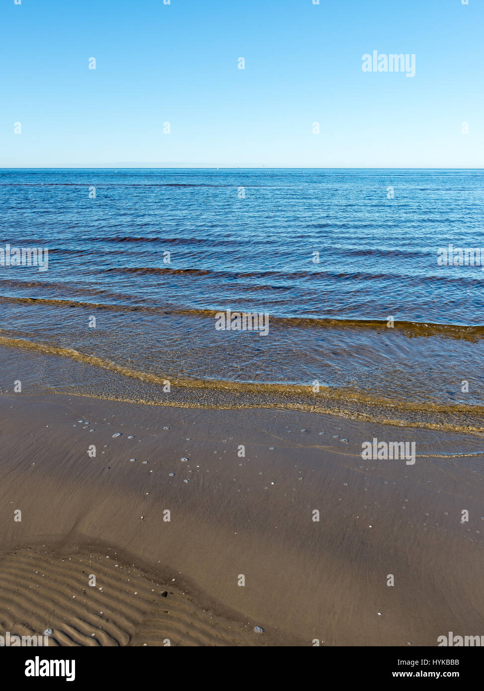 frozen sea beach with blue sky and snow covered tracks Stock Photo - Alamy