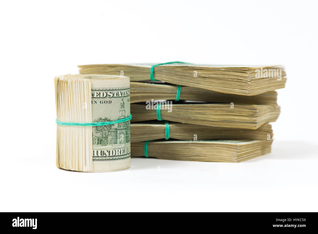 A twisted bundle of 100 dollar bills stands on packs of dollars ...