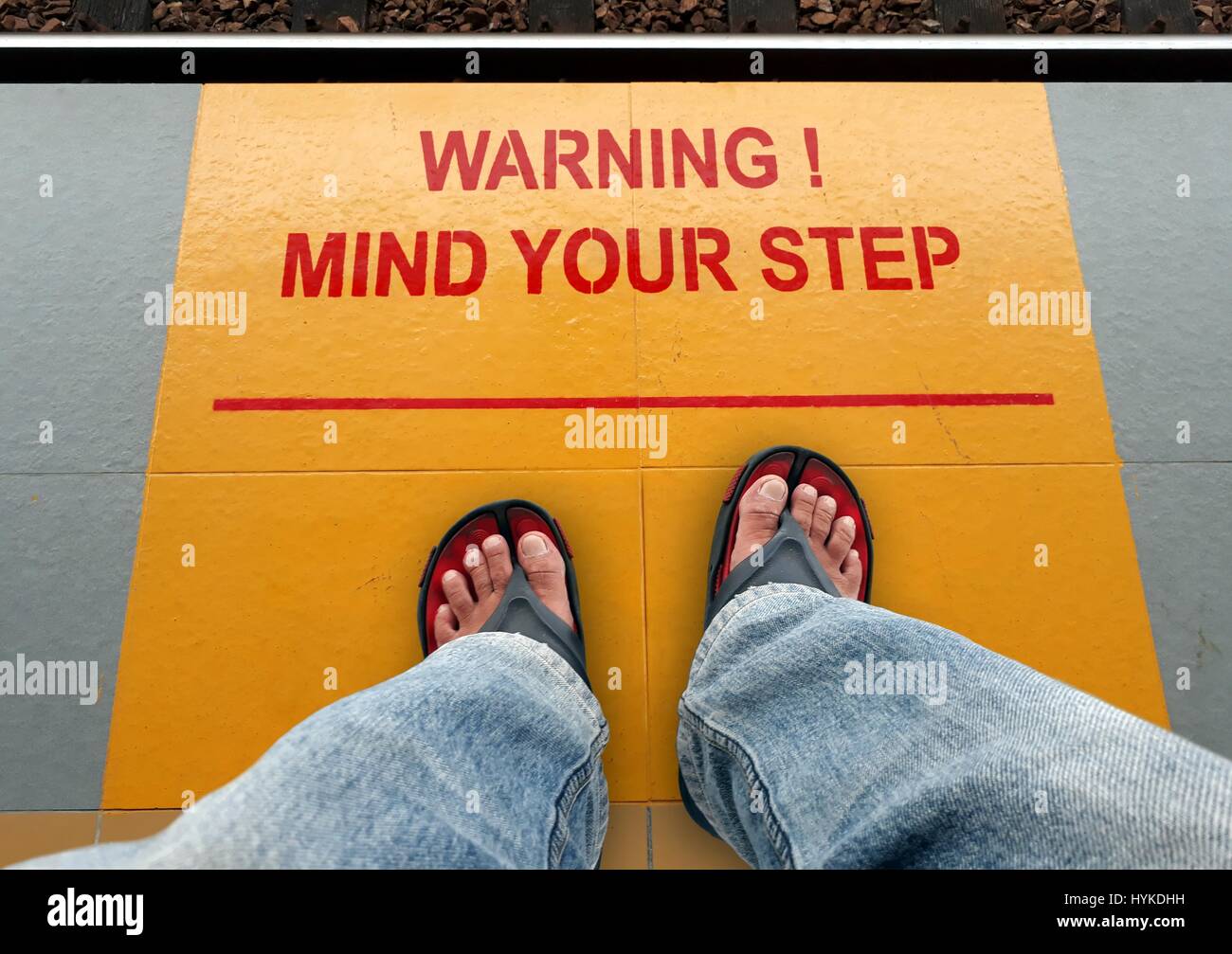 Mind your step signage on a train platform with a man standing Stock ...