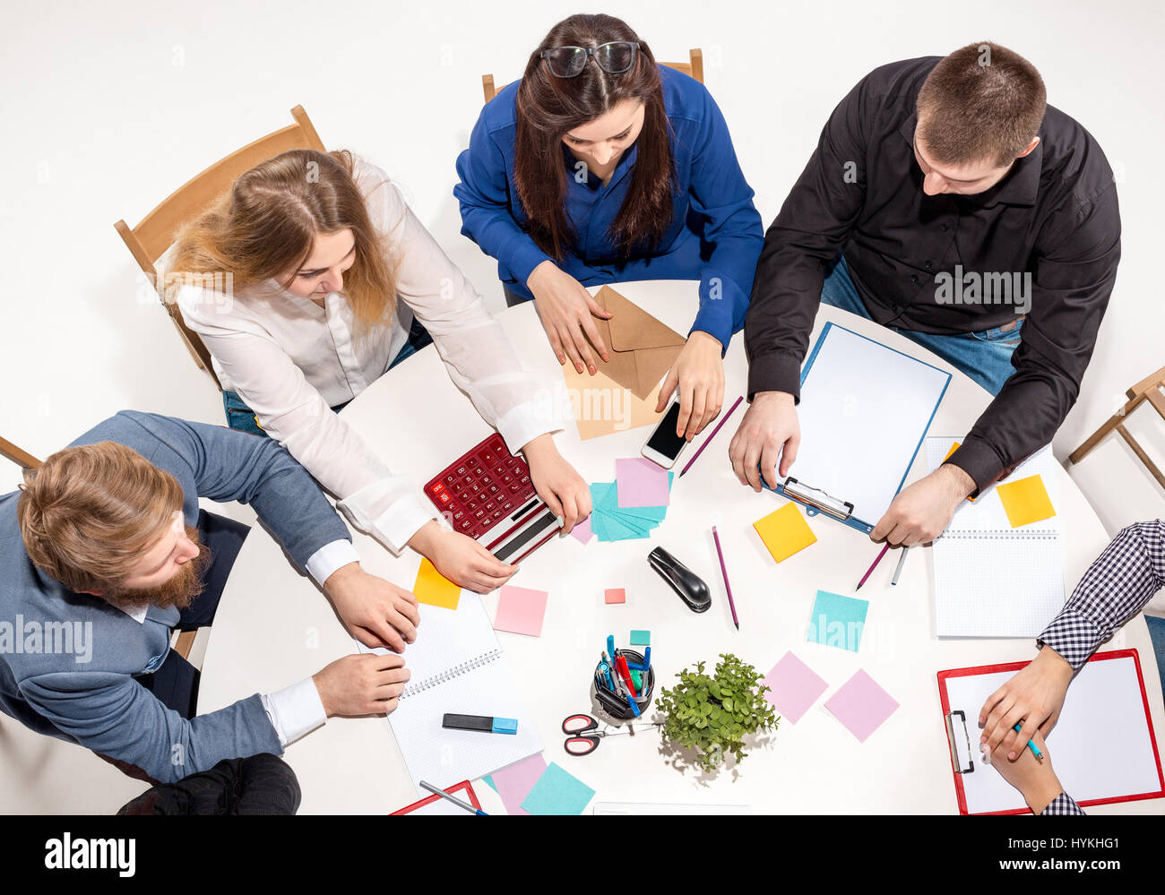 Team sitting behind desk, checking reports, talking. Top View Stock ...