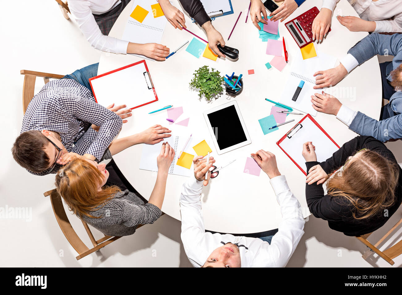 Team sitting behind desk, checking reports, talking. Top View Stock ...
