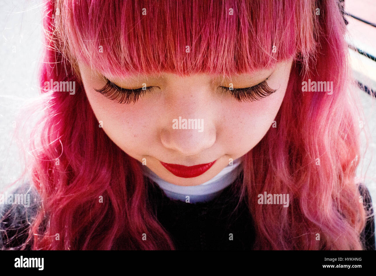 Japanese girl with pink hair in the Shibuya district, Tokyo. Shibuya is ...