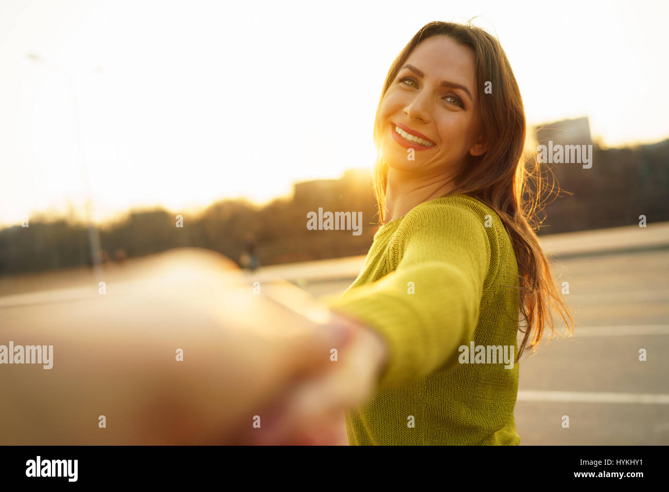 Follow me - happy young woman pulling guy's hand - hand in hand walking ...