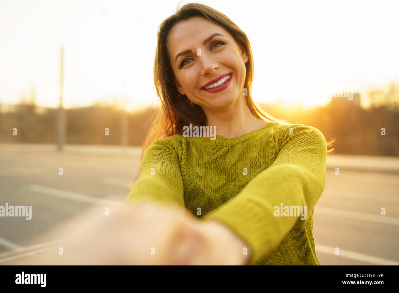 Follow me - happy young woman pulling guy's hand - hand in hand walking ...