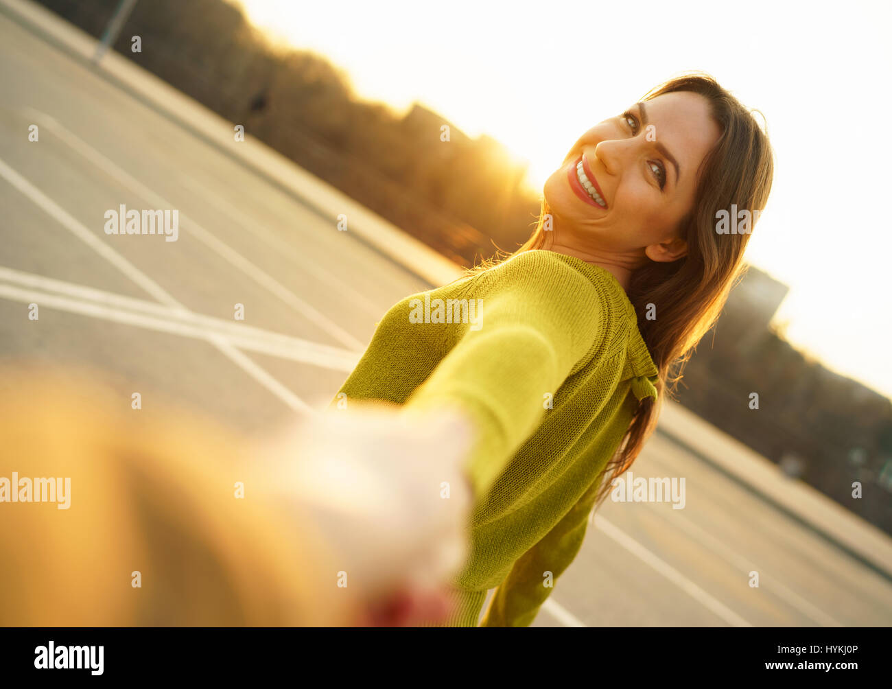 Follow me - happy young woman pulling guy's hand - hand in hand walking ...