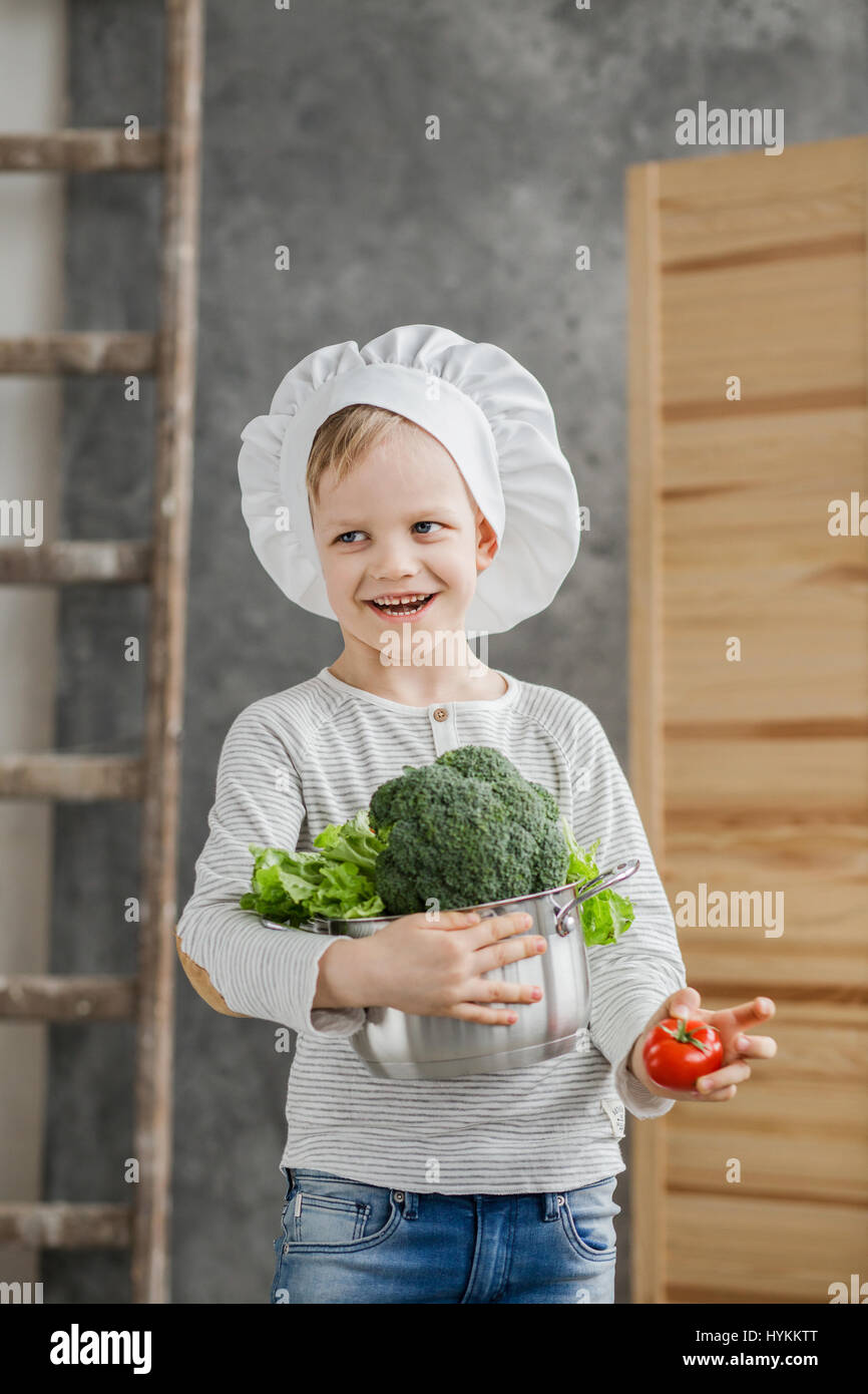 Handsome beautiful boy holding a pot full of vegetables. Healthy food ...