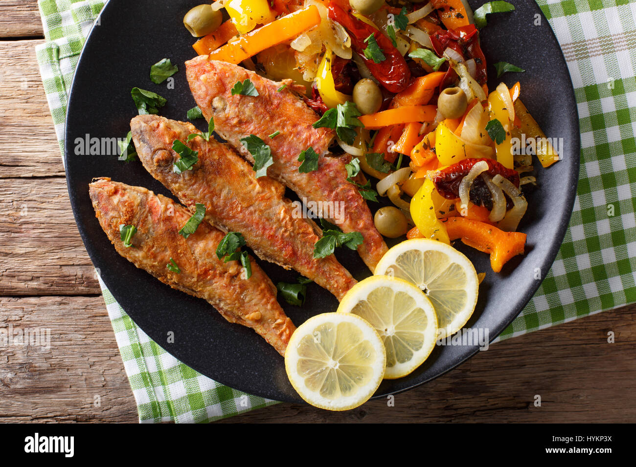 Roasted red mullet with garnish of stewed vegetables close-up on a ...