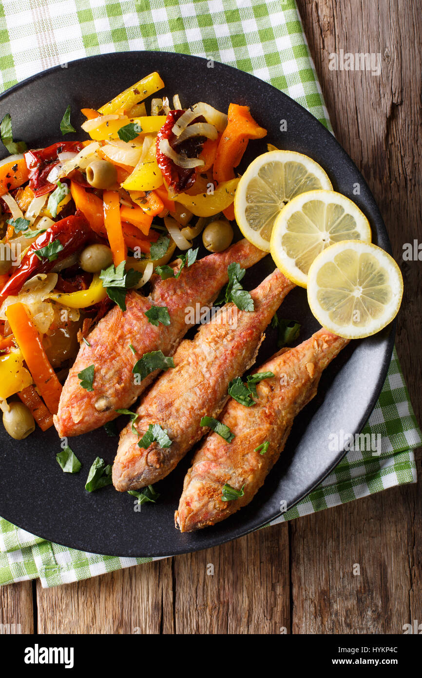 Roasted red mullet with garnish of stewed vegetables close-up on a ...