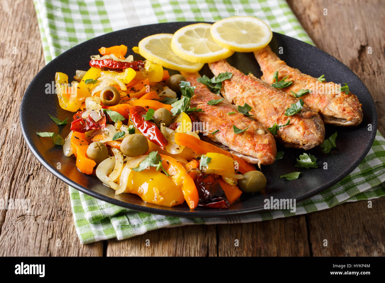 Roasted red mullet with garnish of stewed vegetables close-up on a ...
