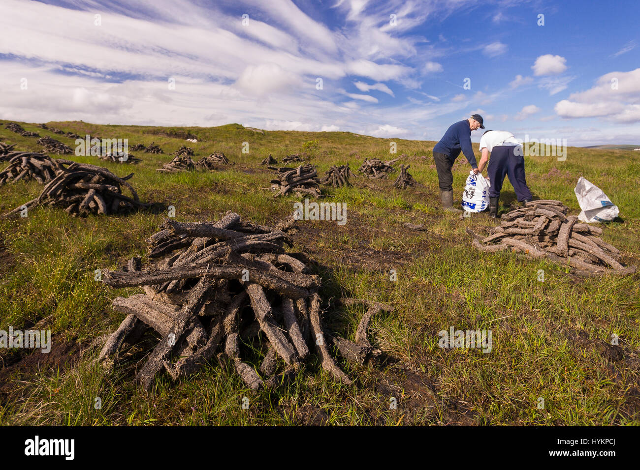 DONEGAL, IRELAND - Farmers harvest peat for fuel, in peatland bog Stock ...