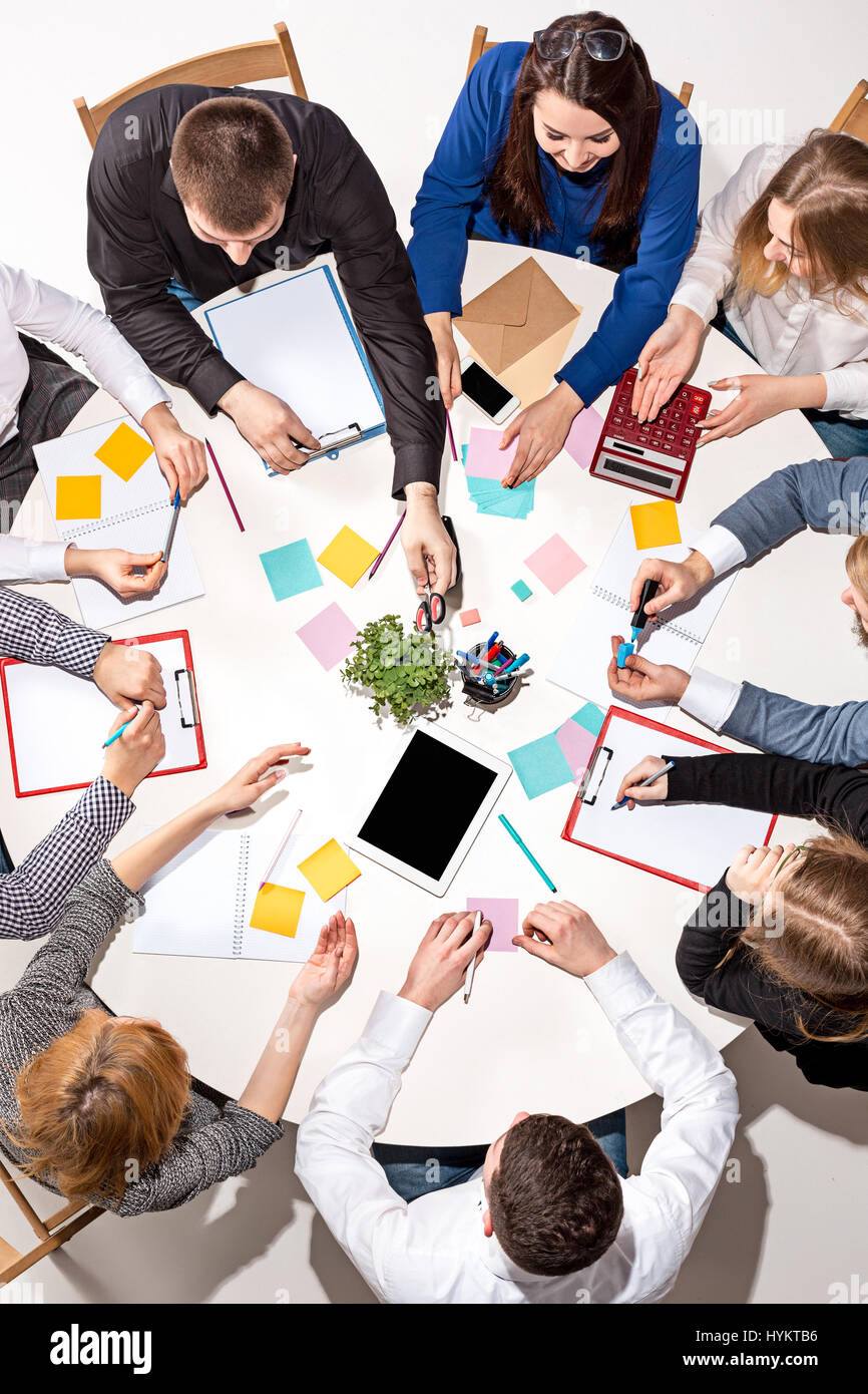 Team sitting behind desk, checking reports, talking. Top View Stock ...