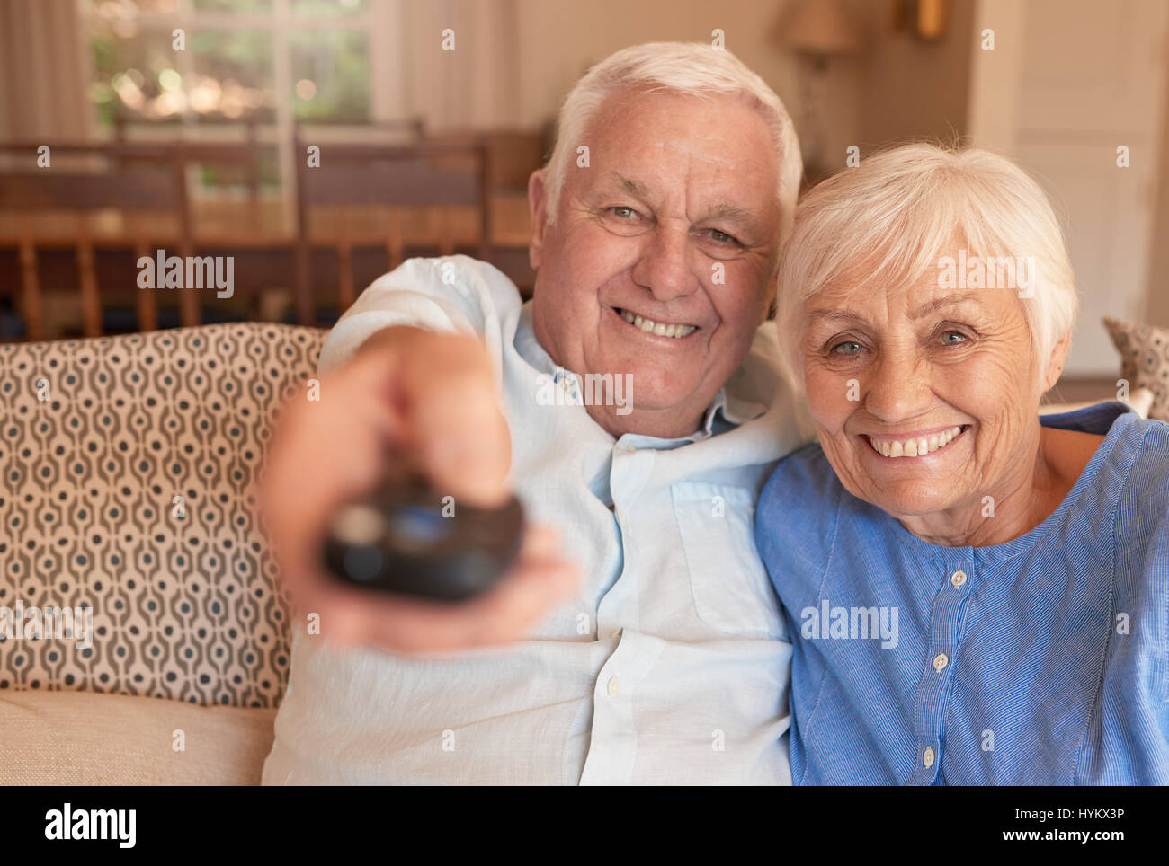 Smiling senior couple changing television channels with a remote Stock ...