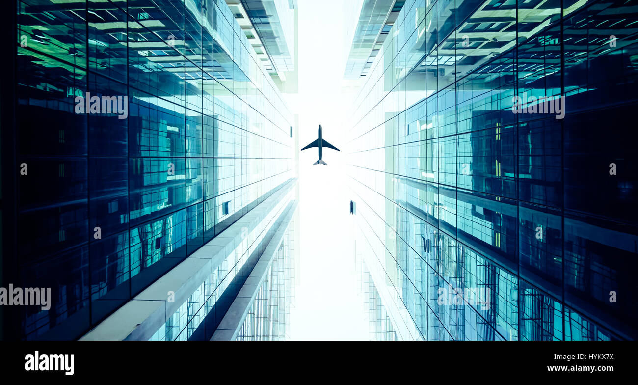 airplane flying above glass office buildings Stock Photo - Alamy